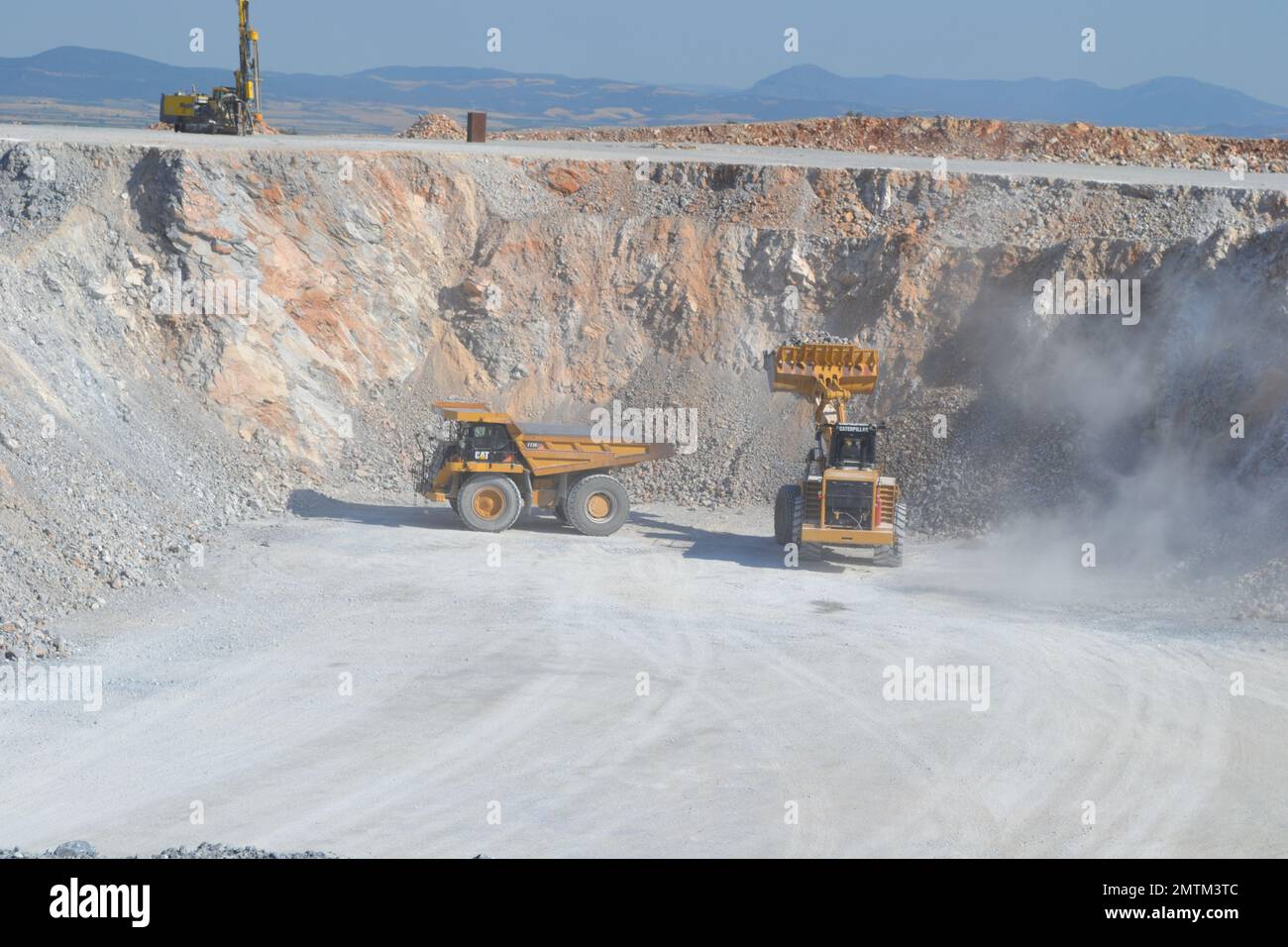Work at a huge limestone quarry, wheel loader loading the dumper, and ...