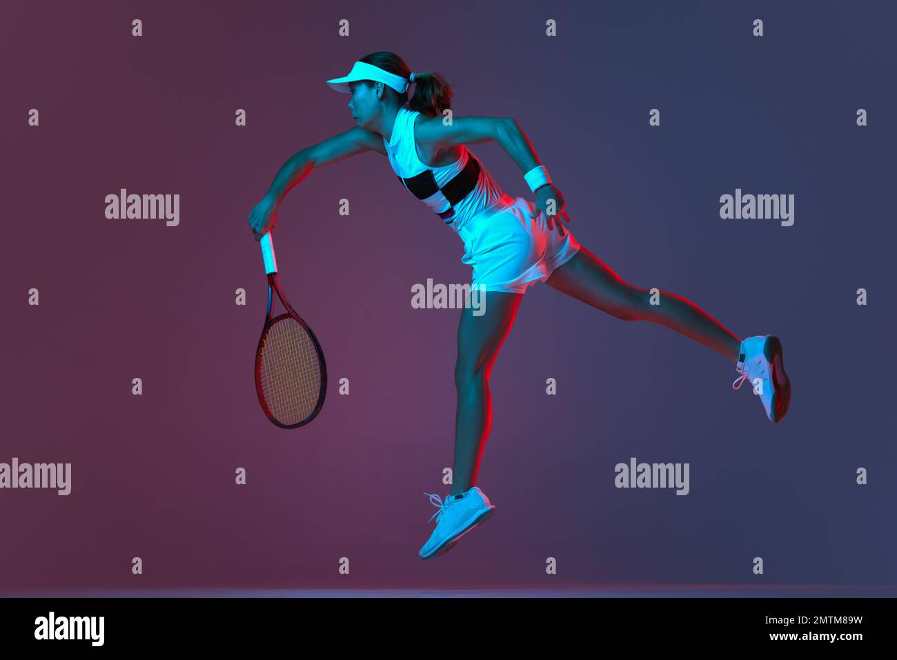 Back view of professional tennis player playing tennis over pink-purple ...