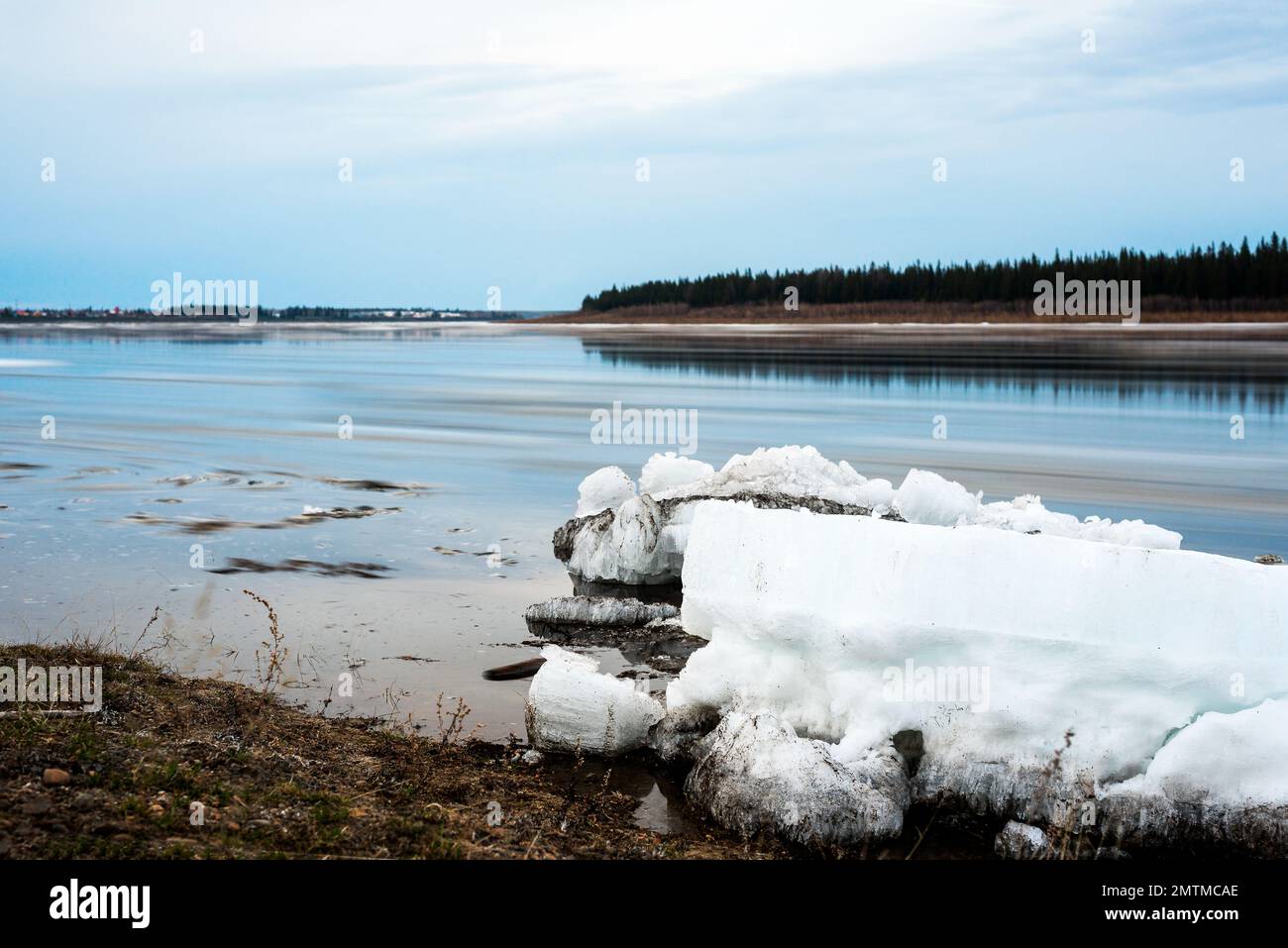 Ice floes lie on the banks of the Vilyui River in shallow water in ...