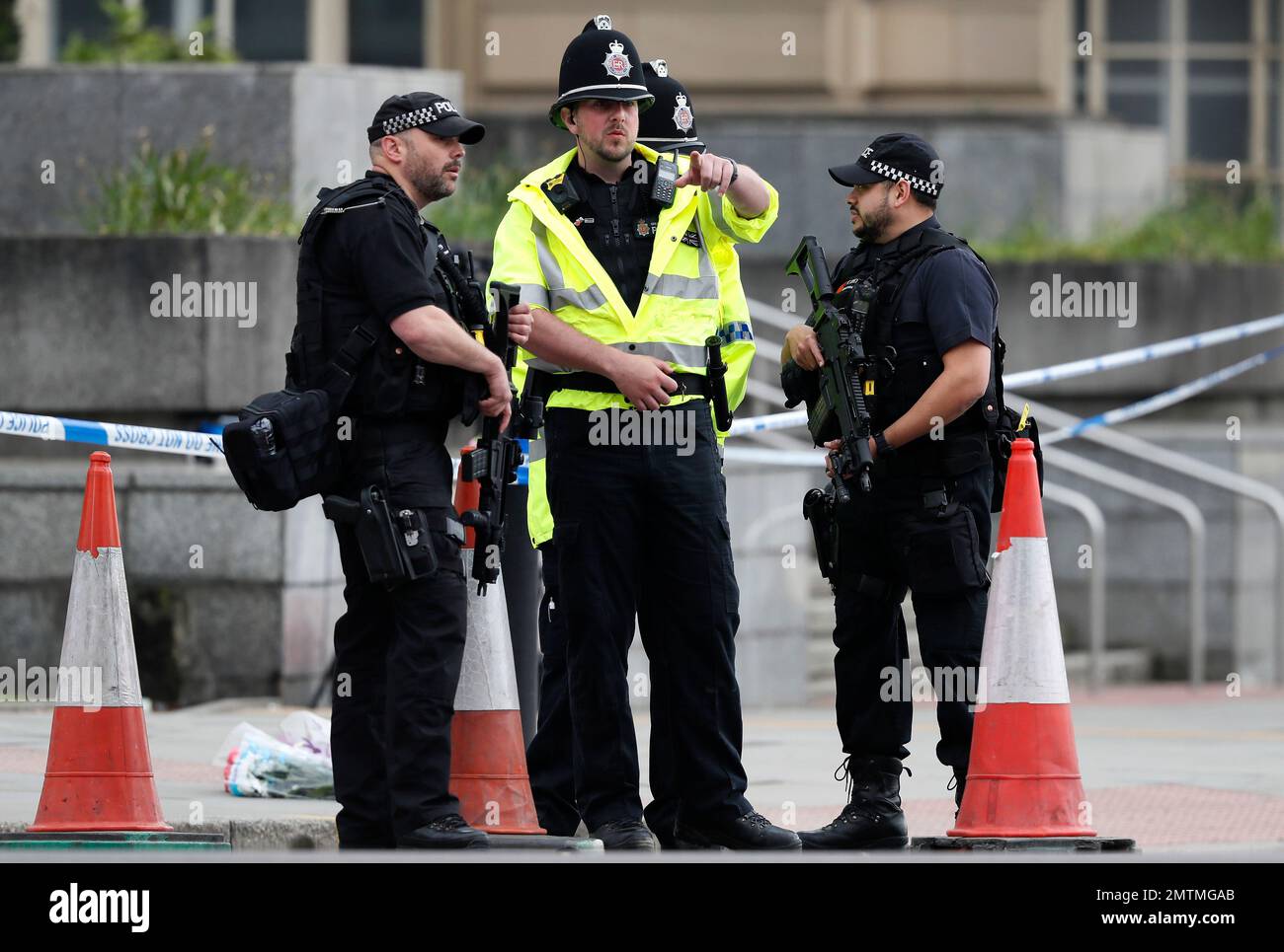 Armed police officers patrol a police cordon near the Manchester Arena ...