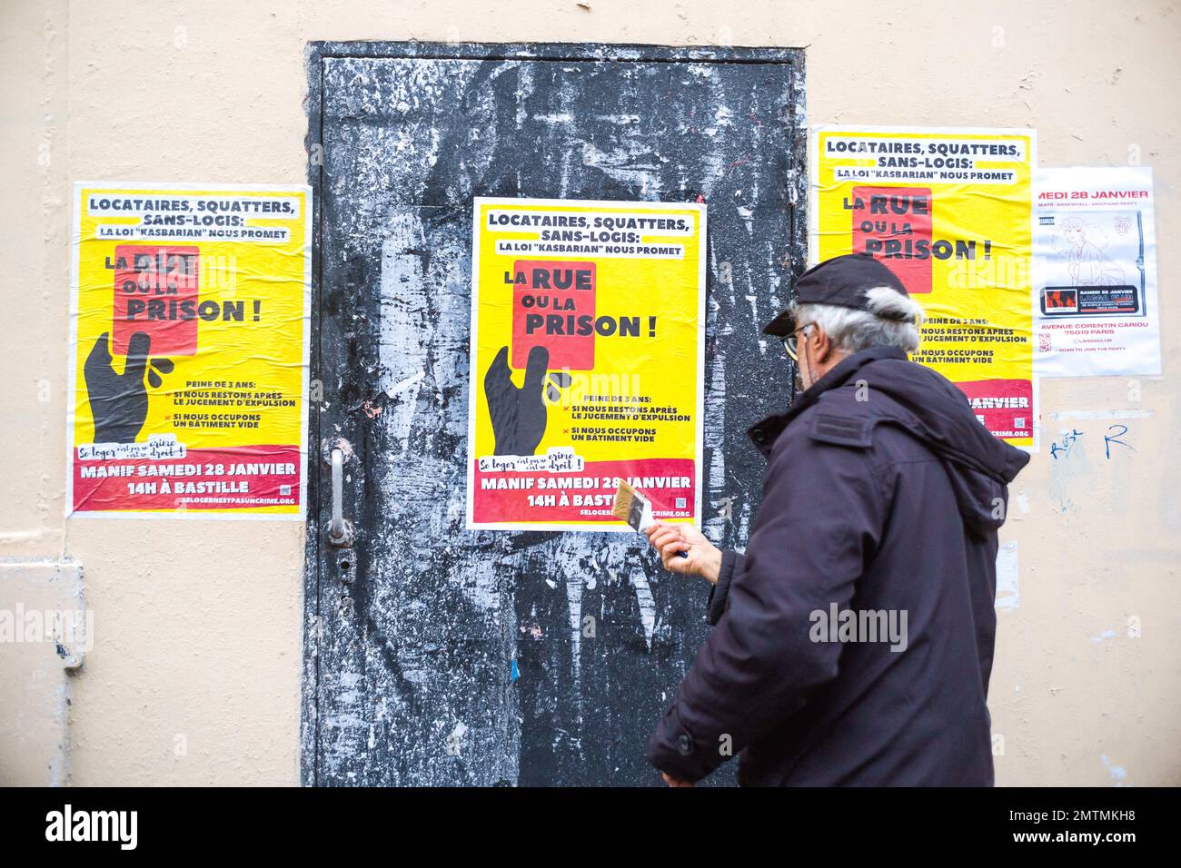 Two men stick posters, Tenants, squatters, homeless: the law "Kasbarian ...