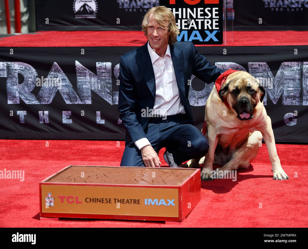 Director Michael Bay poses with his dog Rebel during a hand and ...