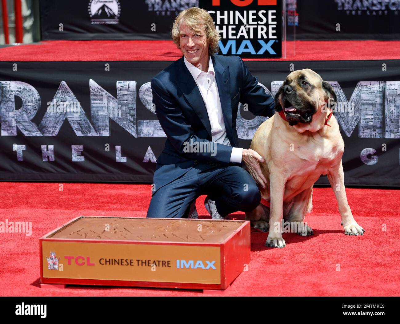 Director Michael Bay poses with his dog Rebel during a hand and ...
