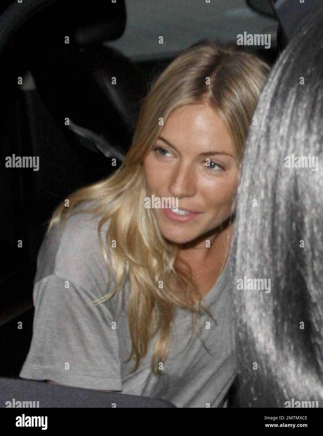 Actress Sienna Miller makes her way through a crowd of fans and ...