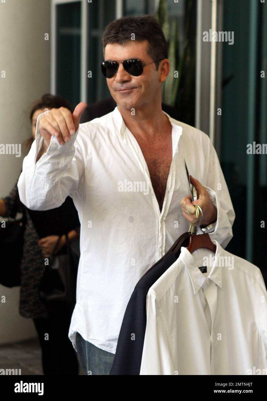 In town for "The X-Factor" auditions, Simon Cowell carries his clothes ...