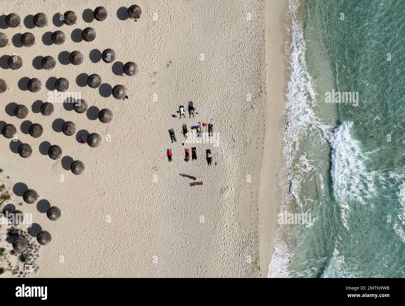 Group of people doing yoga at the beach. Exercising outdoor. Nissi ...
