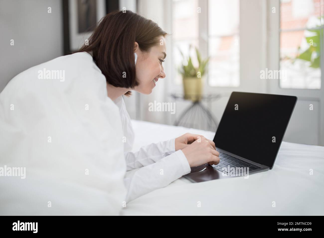 Young woman chilling in bed with computer at home, mockup Stock Photo ...