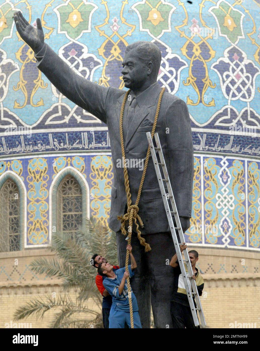 FILE- In this April 9, 2003 file photo, Iraqi civilians secure a rope ...