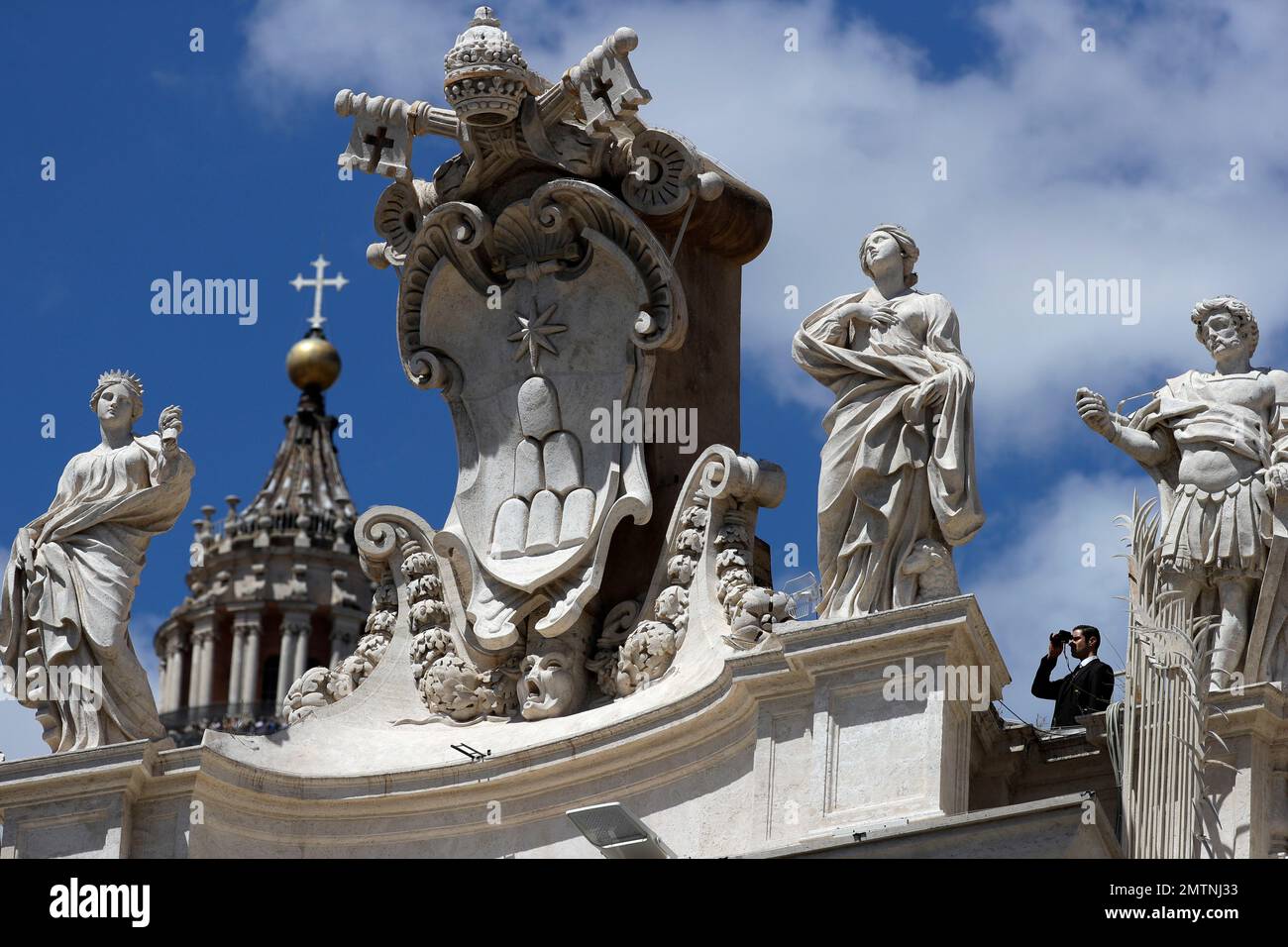 A Vatican security guard uses a binocular prior to the start of Pope ...