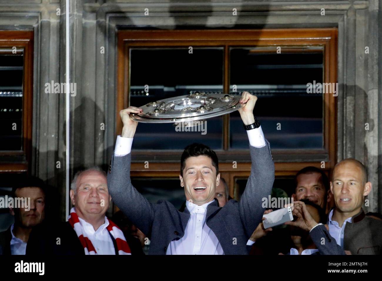 Bayern's Robert Lewandowski lifts the trophy as his team celebrate on ...