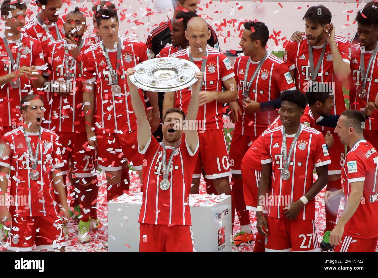 Bayern's Xabi Alonso lifts the trophy as his team celebrate winning the ...