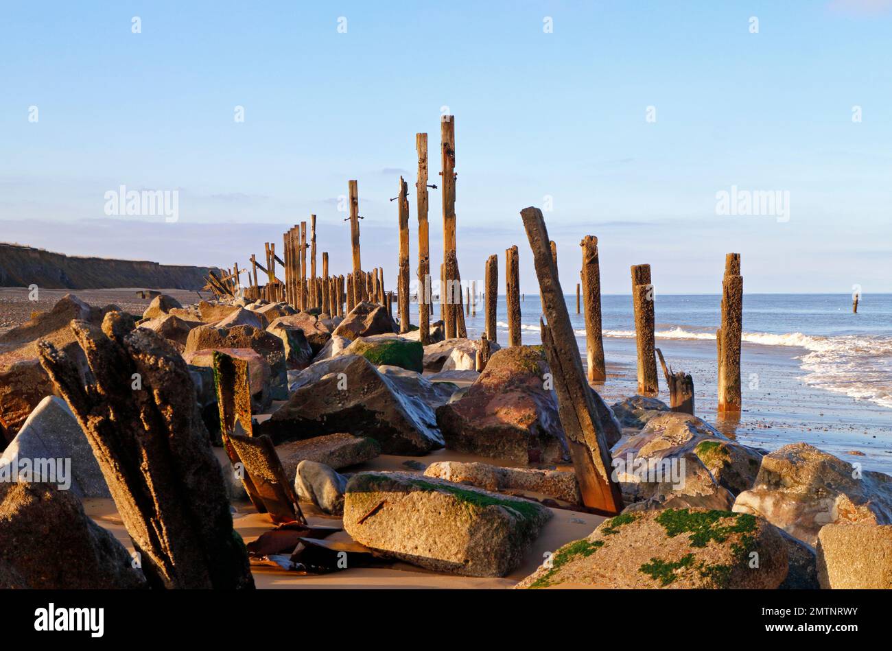 Old deteriorating timber breakwaters reinforced with imported rocks in ...