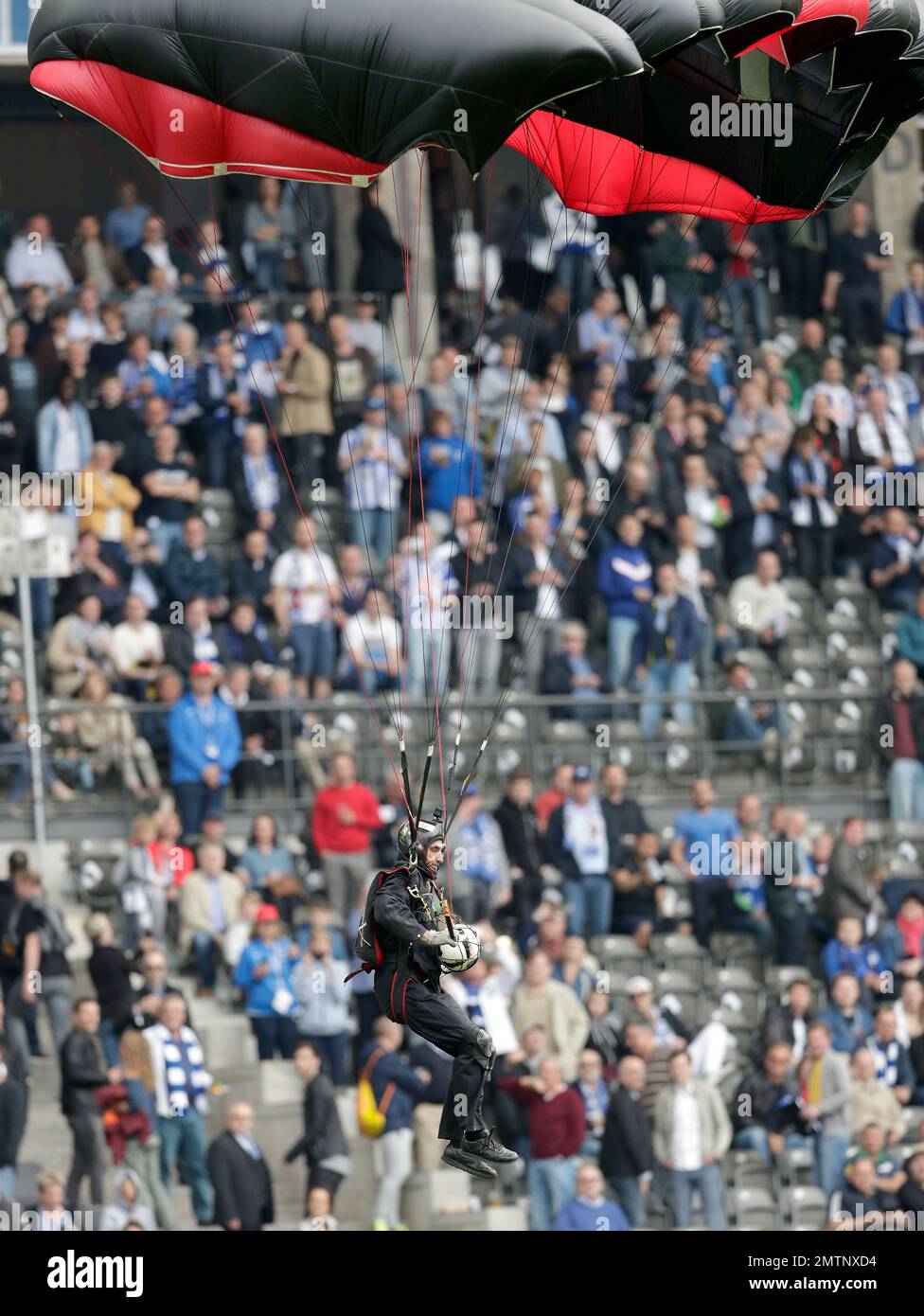 A skydiver, who jumped off the stadium roof, delivers the match ball ...