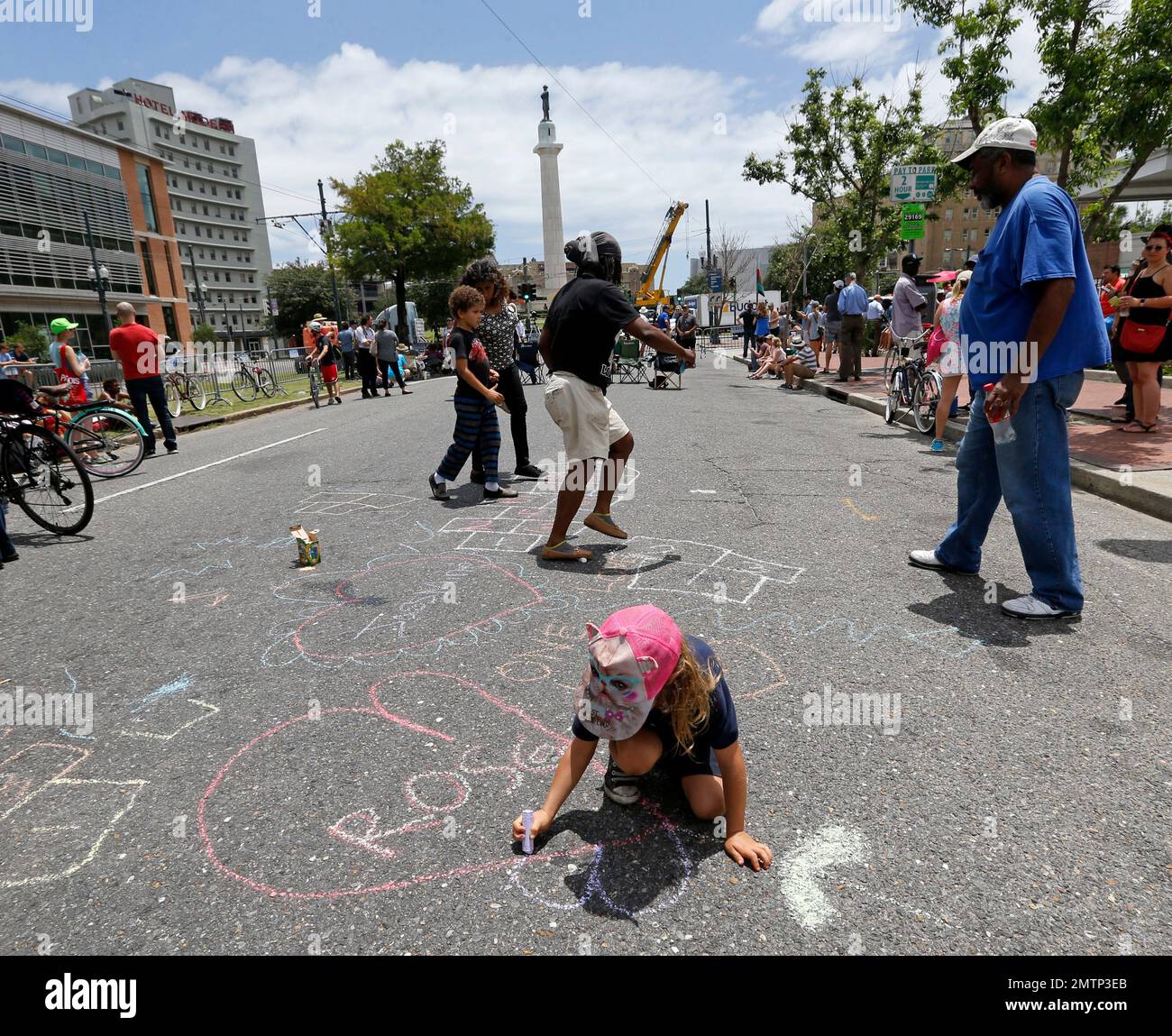 Roscoe Adair 6, draws a heart with chalk in the street as workers ...