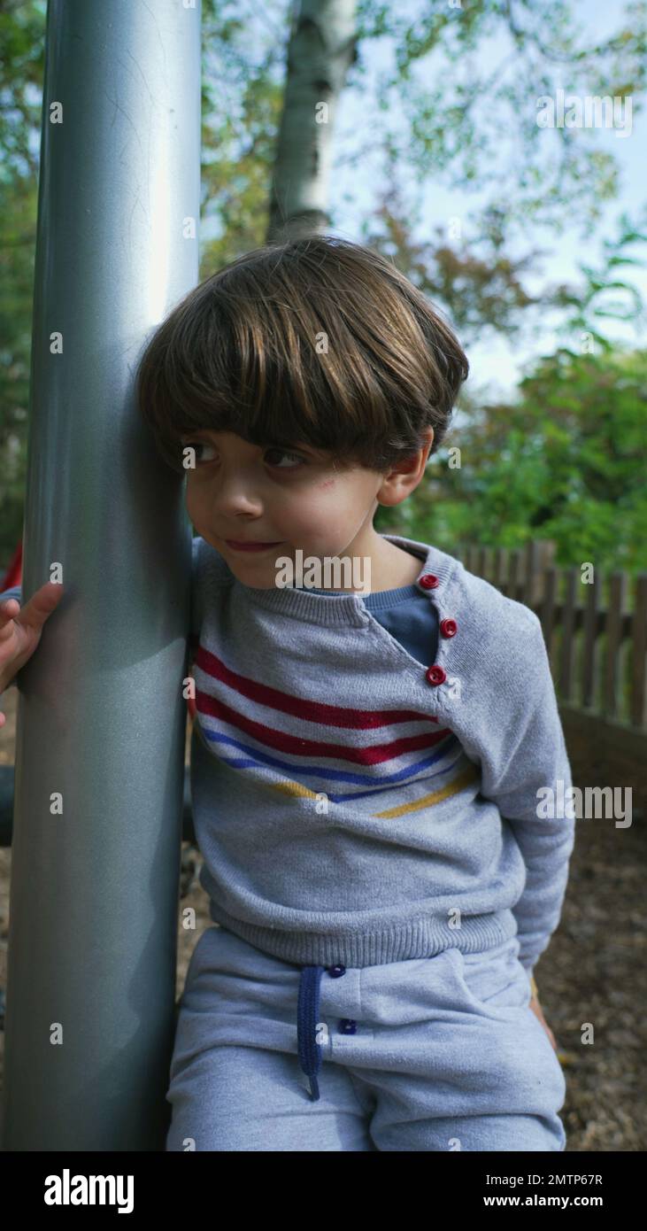 One adorable little boy sitting at playground park structure smiling at ...
