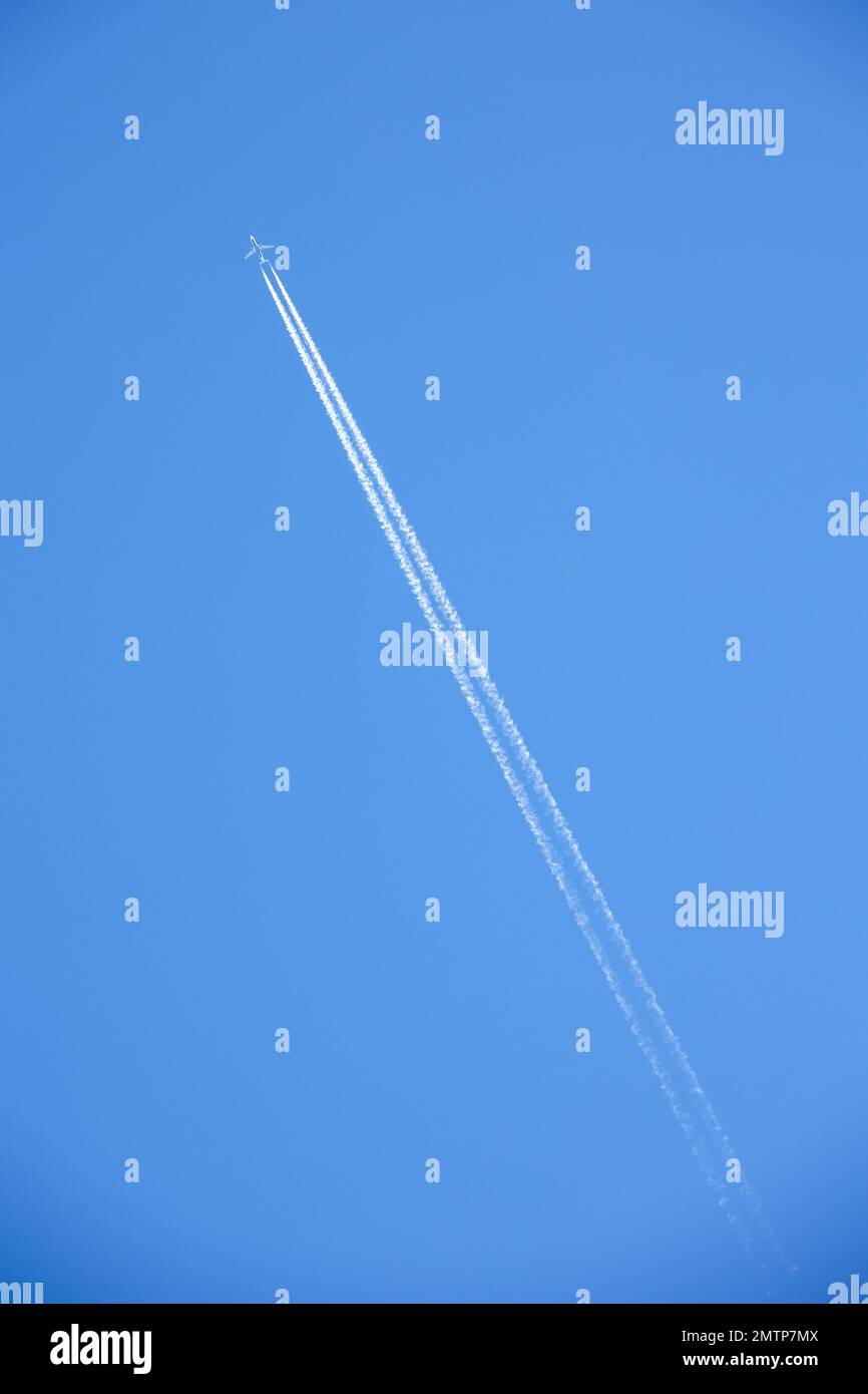 An aerial view of plane leaving white lines in sky Stock Photo - Alamy