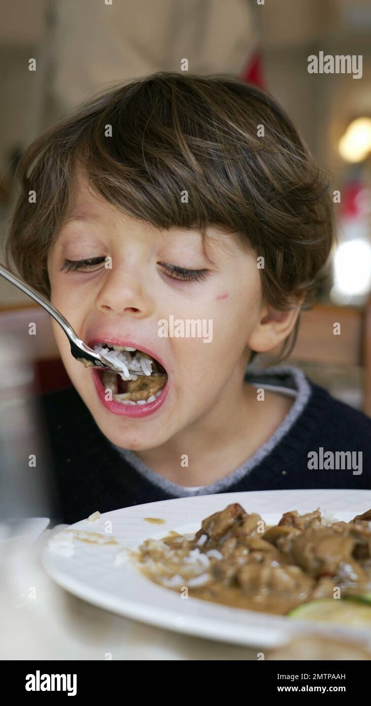 Mother feeds food to little boy son. Child blowing hot food sitting at ...