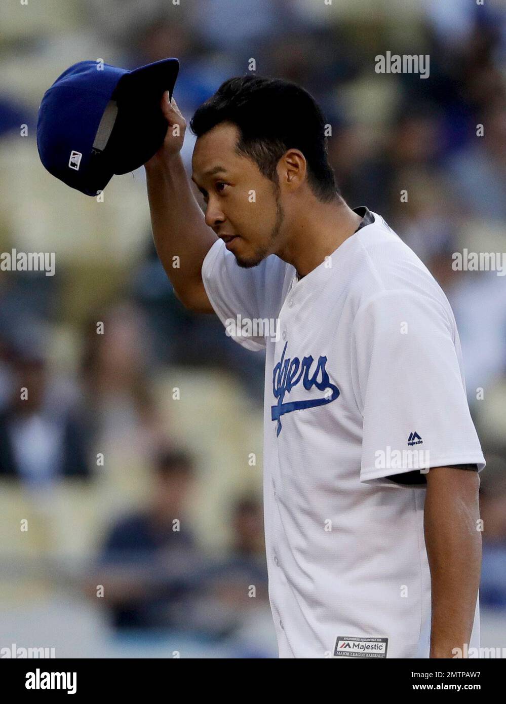 Former Olympic swimmer Kosuke Kitajima, of Japan, tips his cap after throwing out the first ...