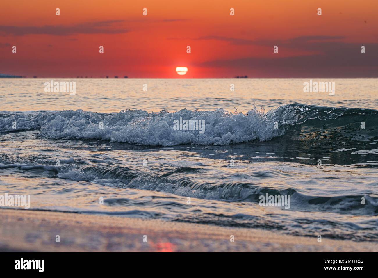 An aerial view of sea waves breaking beach during sunset Stock Photo ...
