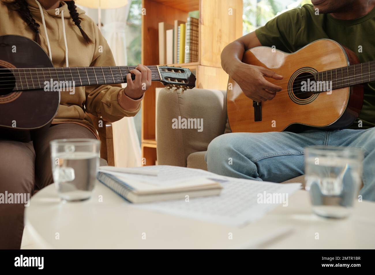Teacher and student playing guitar together at home Stock Photo - Alamy