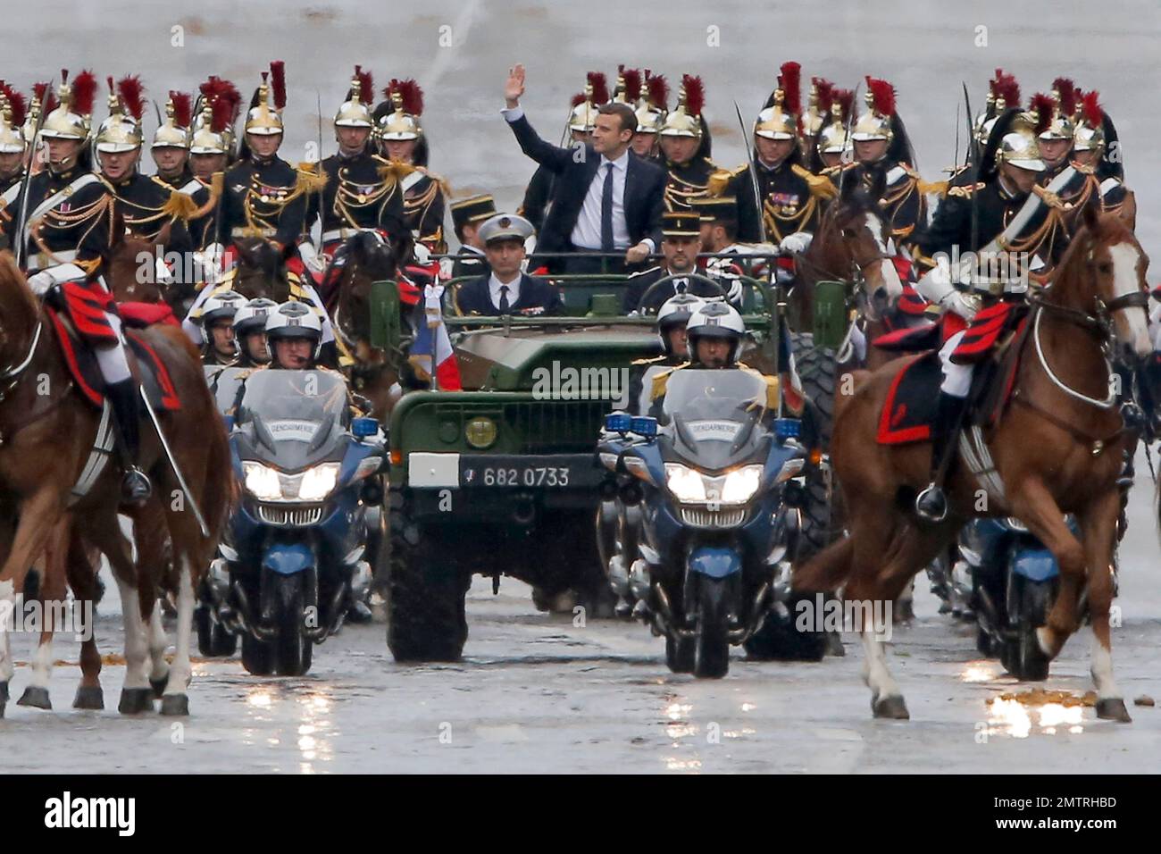 New French President Emmanuel Macron waves from a military vehicle as ...