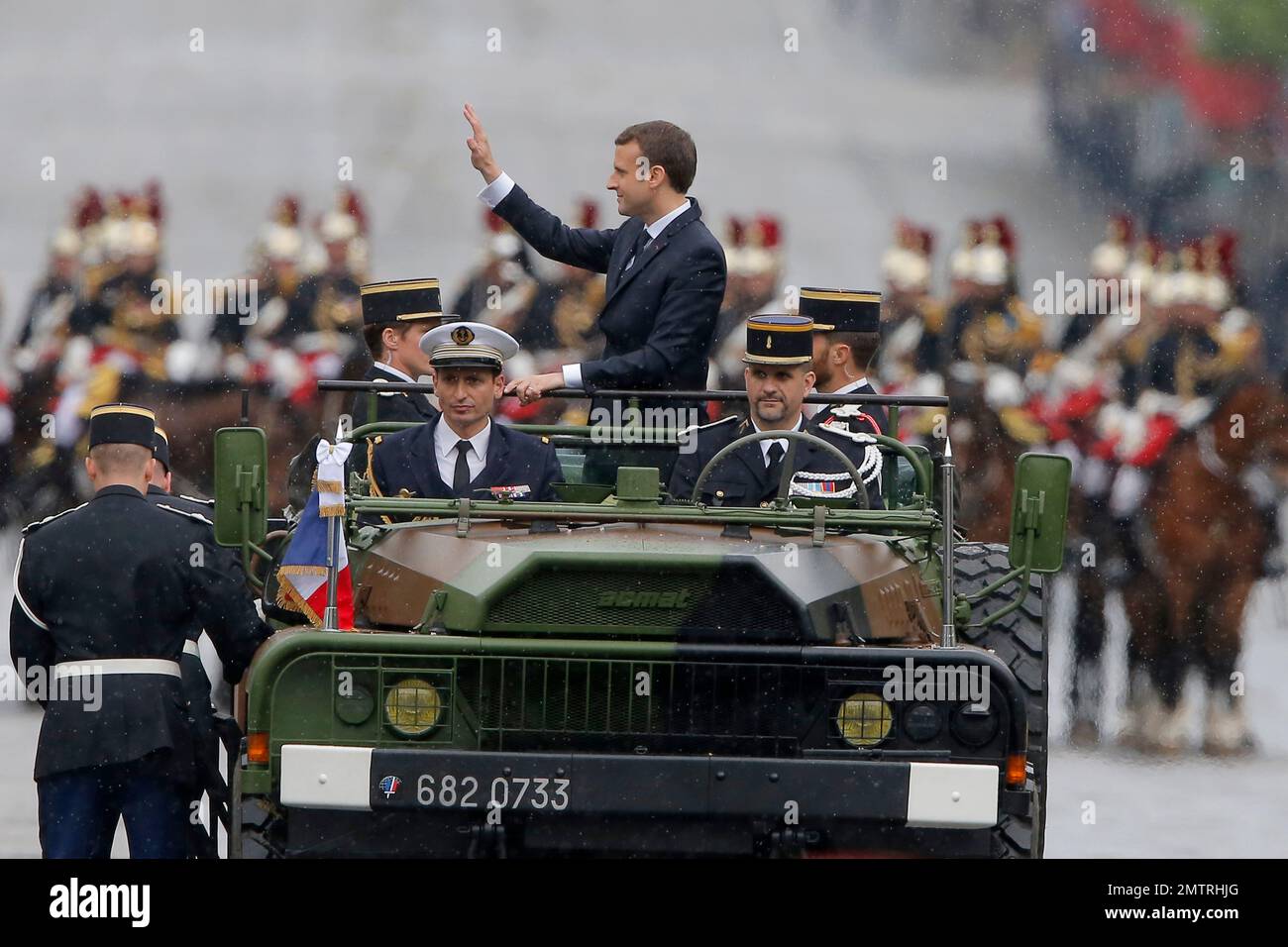 New French President Emmanuel Macron waves from a military vehicle as ...