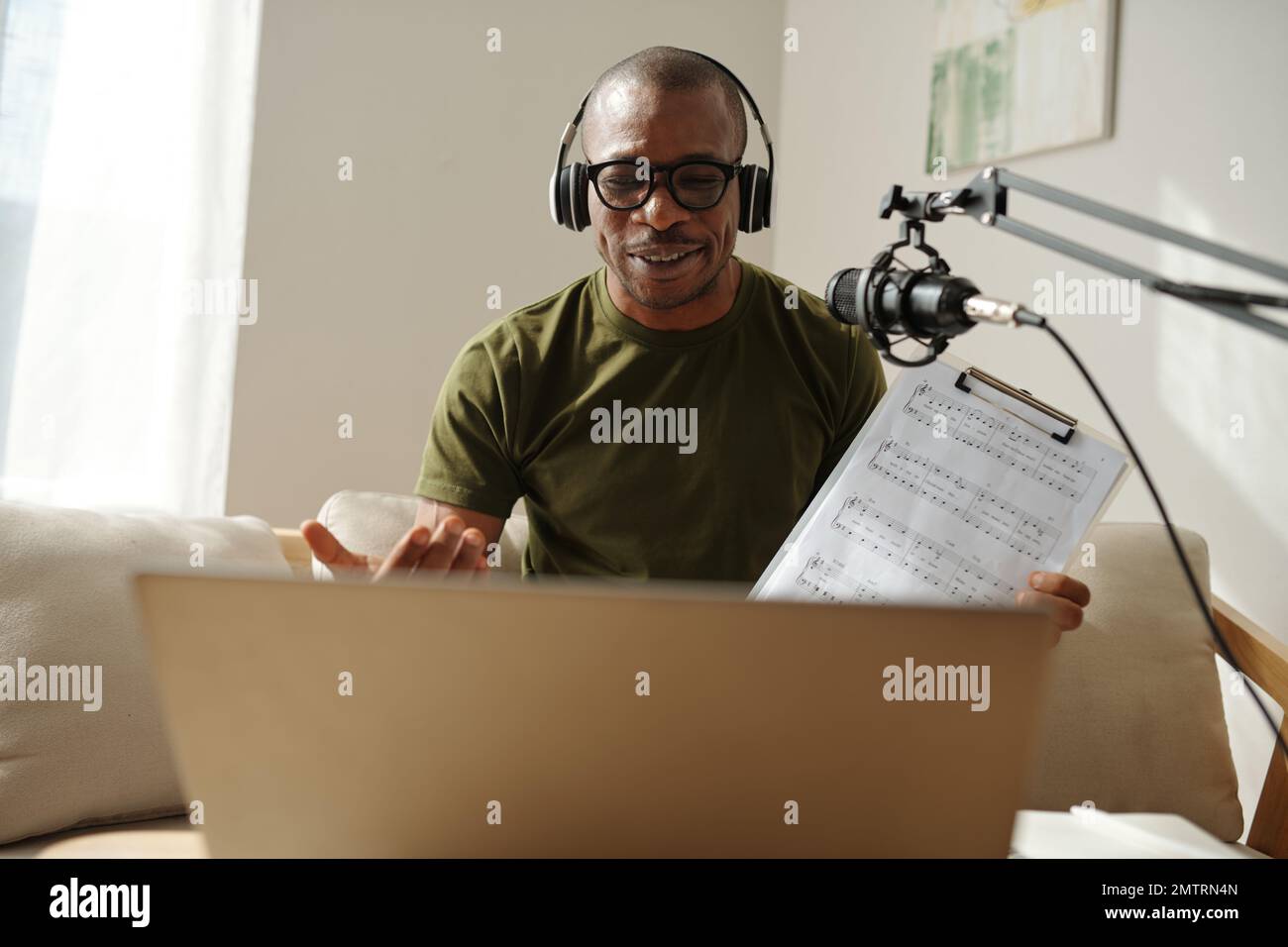 Smiling man conducting online lesson on music notes Stock Photo - Alamy
