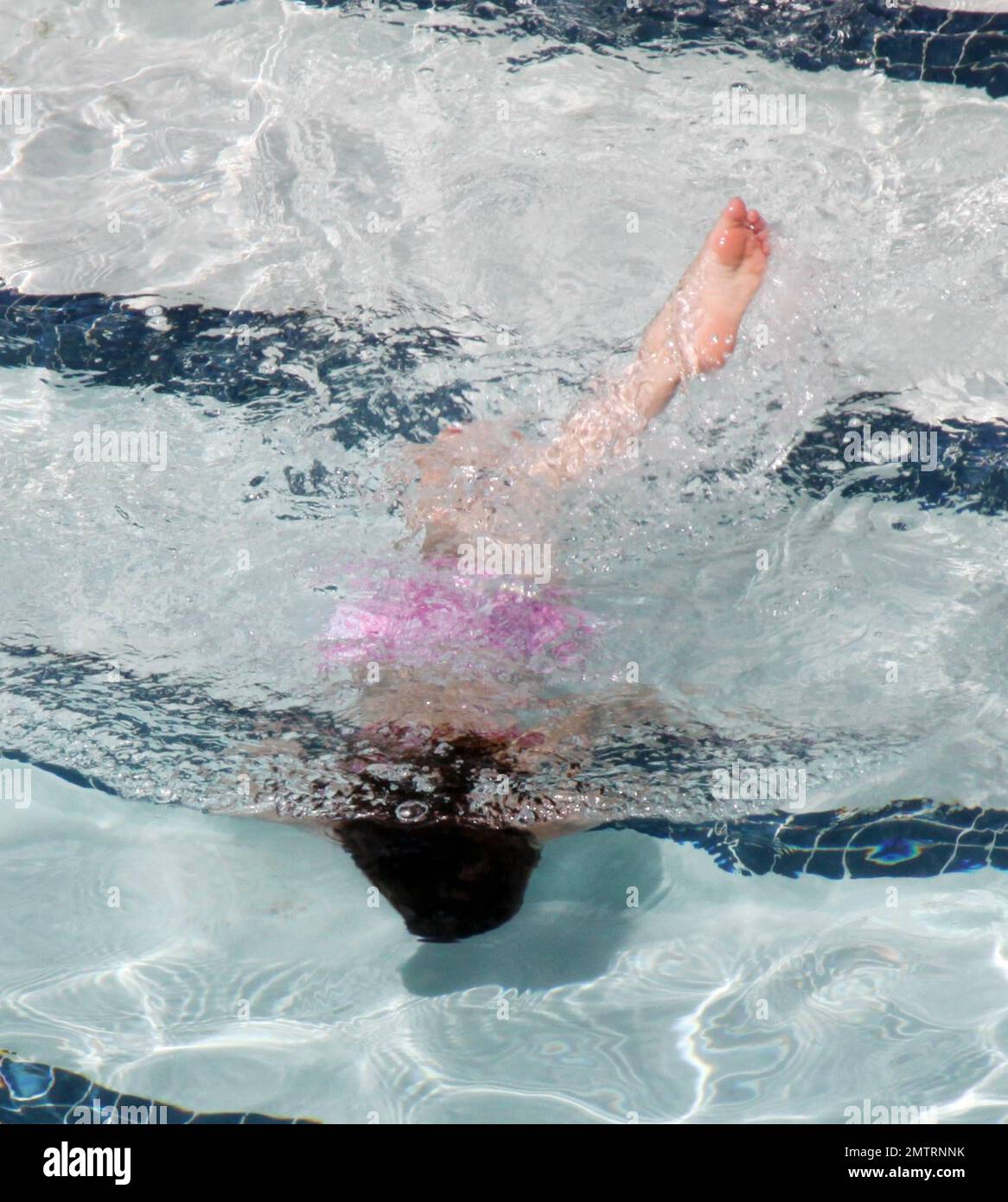 Suri Cruise shows off her improving swimming skills in the pool. Suri ...