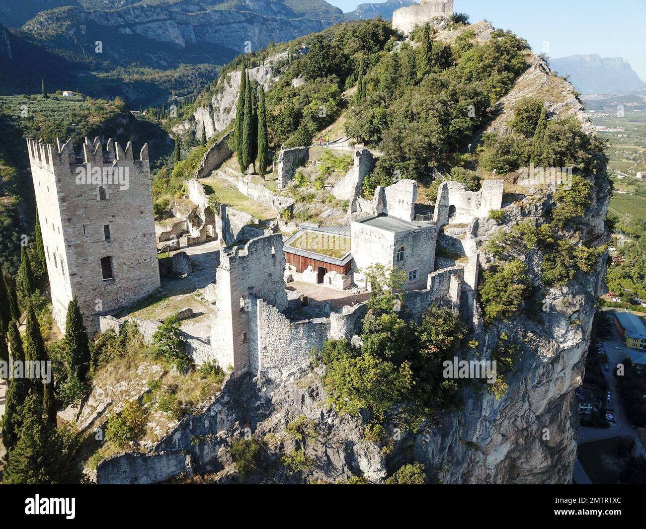 An aerial of the medieval Arco Castle in Italy on top of the mountains ...