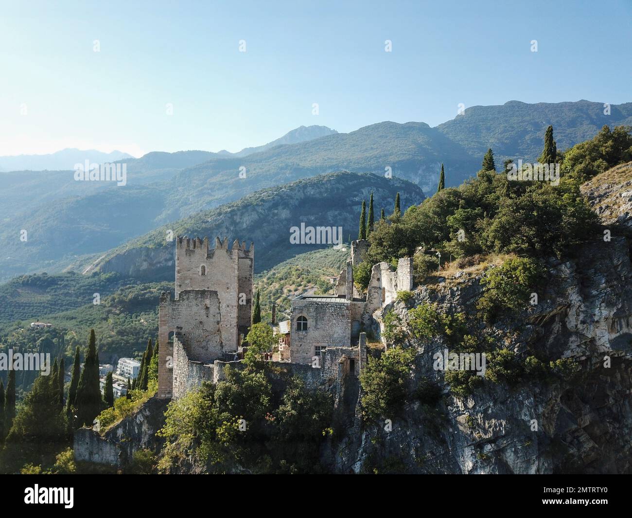 An aerial of the medieval Arco Castle in Italy on top of the mountains ...
