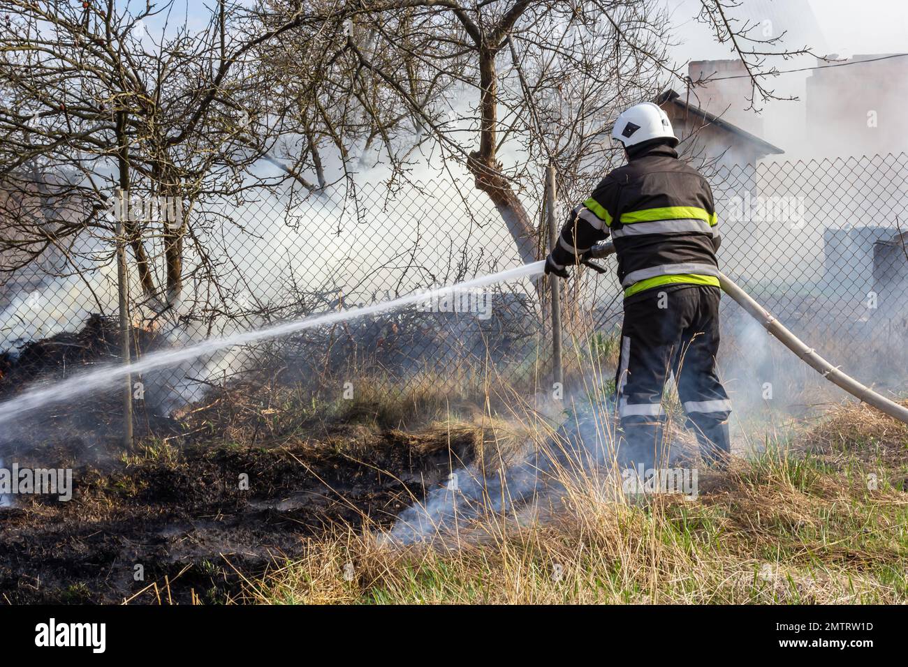 spring fire, burning dry grass near buildings in the countryside ...