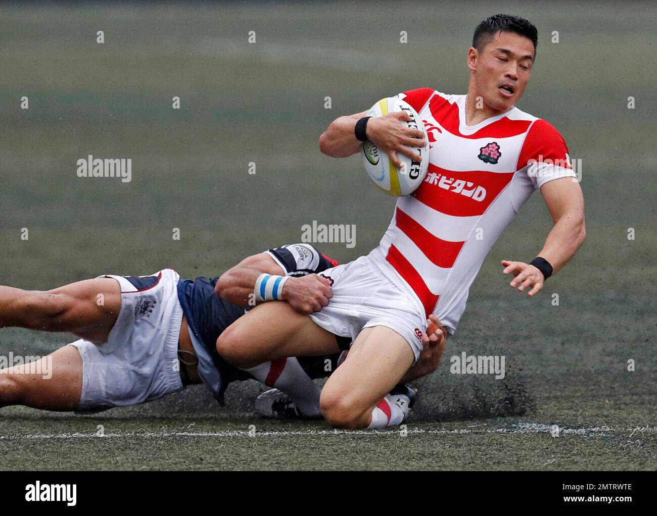 CORRECTS NAMES OF PLAYERS - Japan's Akihito Yamada, right, is tackled ...