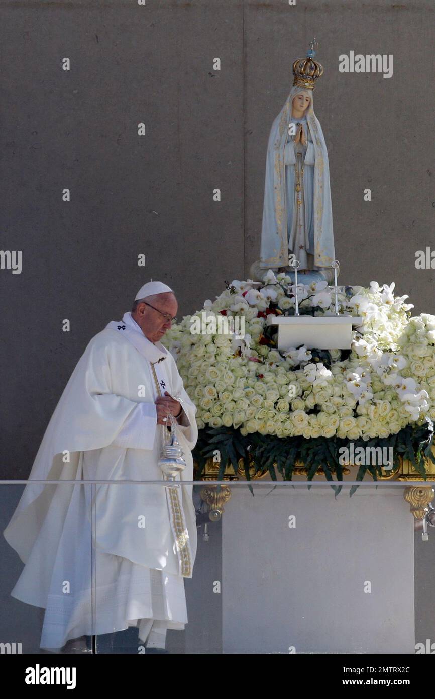 Pope Francis walks past the statue of the Virgin Mary as he celebrates ...