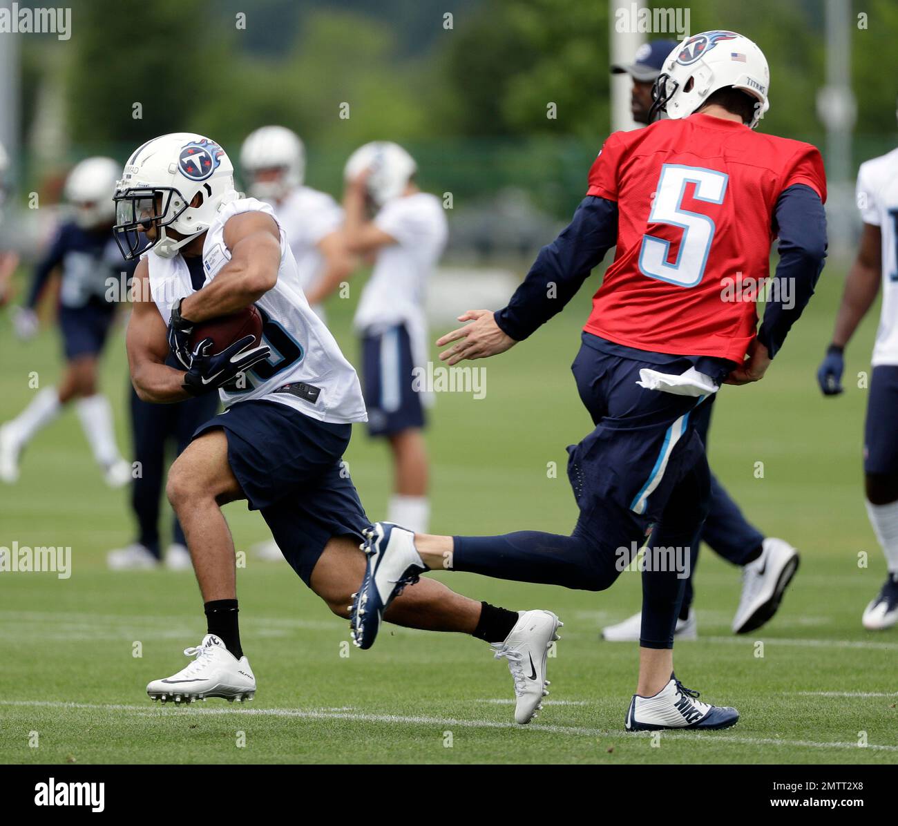 Tennessee Titans running back Khalfrani Muhammed, left, takes a handoff ...