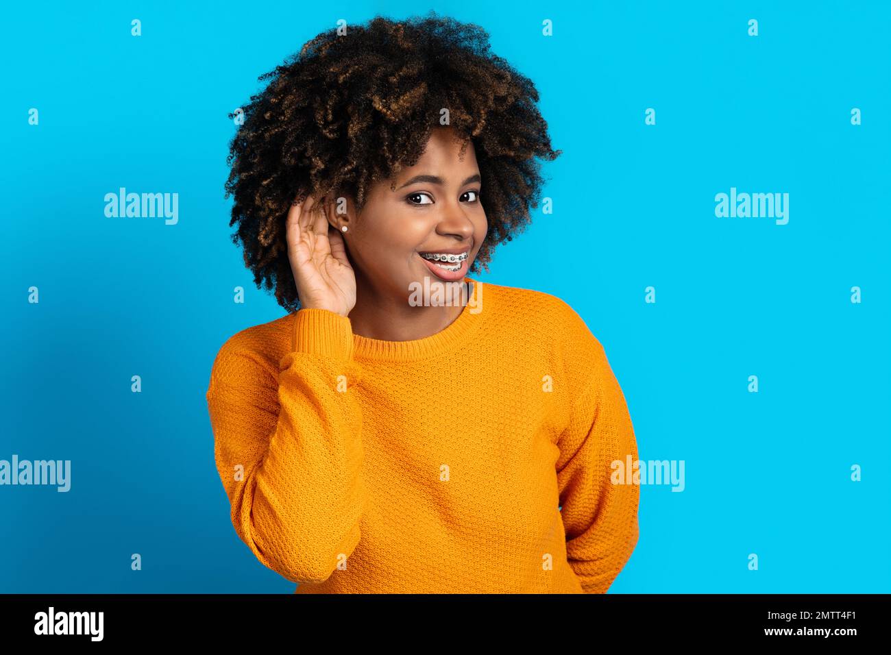 Beautiful african woman holding hand near ear trying to listen Stock ...