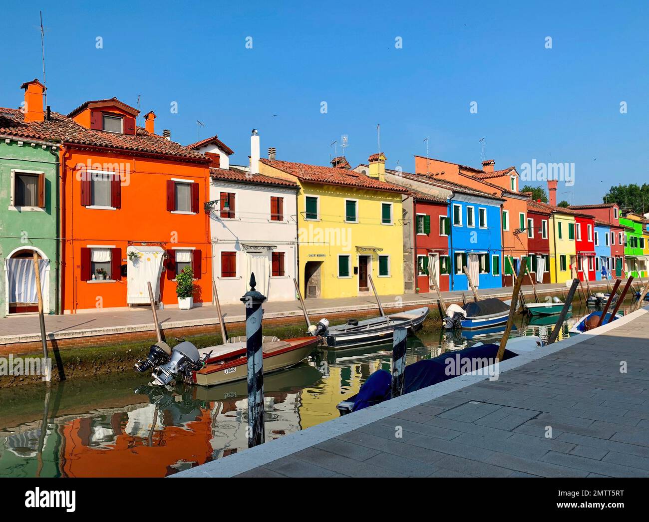The exterior of colorful canalside houses on the island of Burano ...
