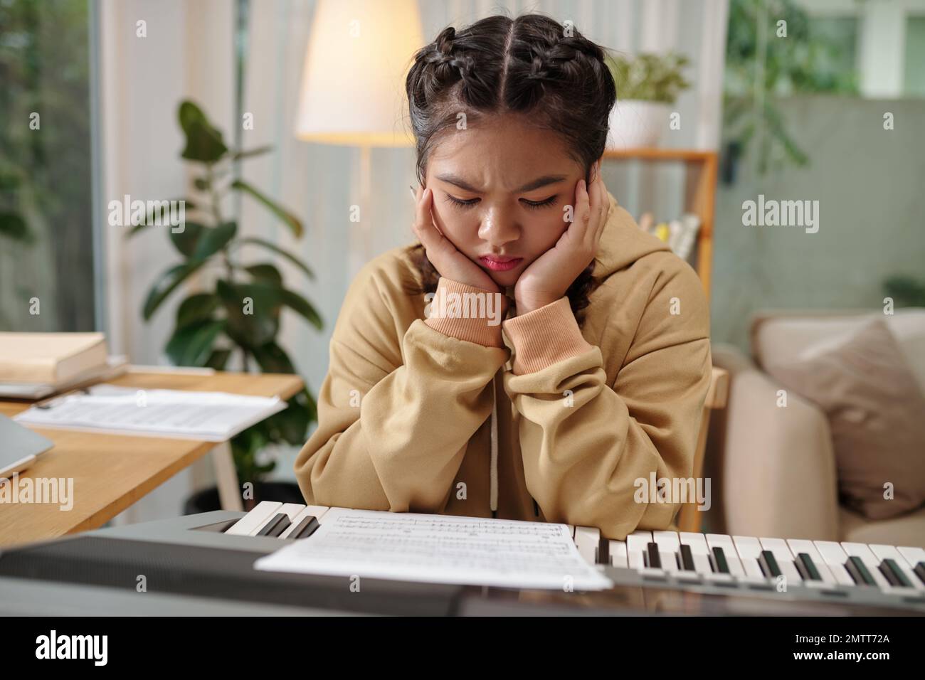 Sad and confused girl looking at paper sheet with music notes Stock ...