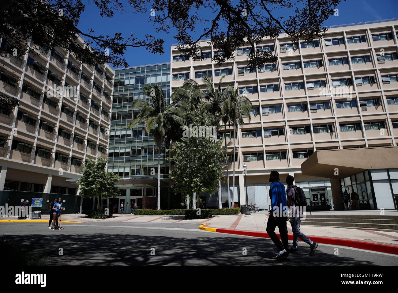 Students walk past a building in the residential area on the campus of ...