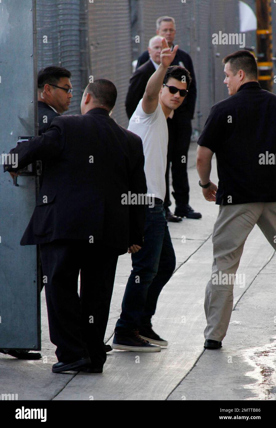 Taylor Lautner waves at fans as he leaves the Jimmy Kimmel Show. Los ...