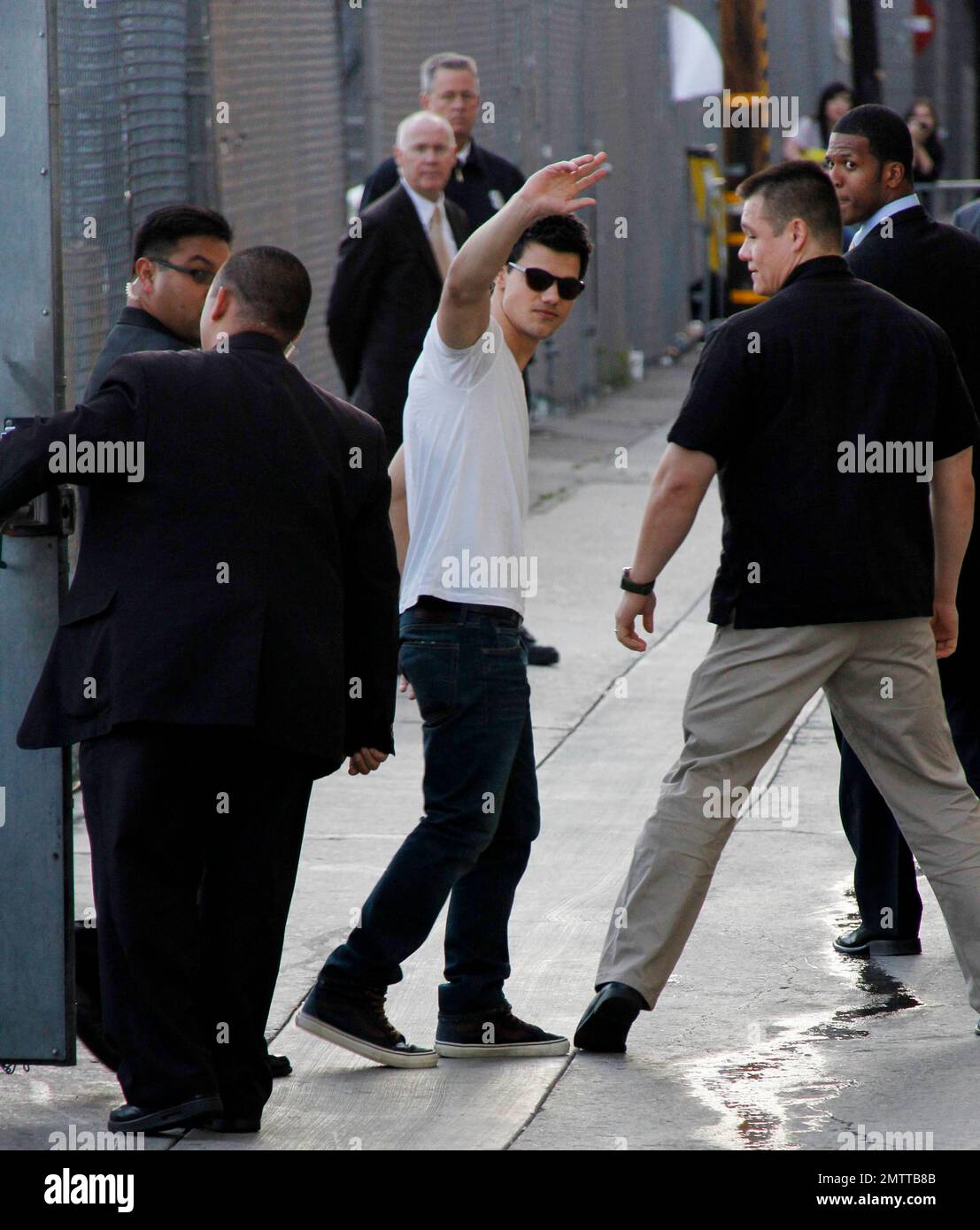 Taylor Lautner waves at fans as he leaves the Jimmy Kimmel Show. Los ...