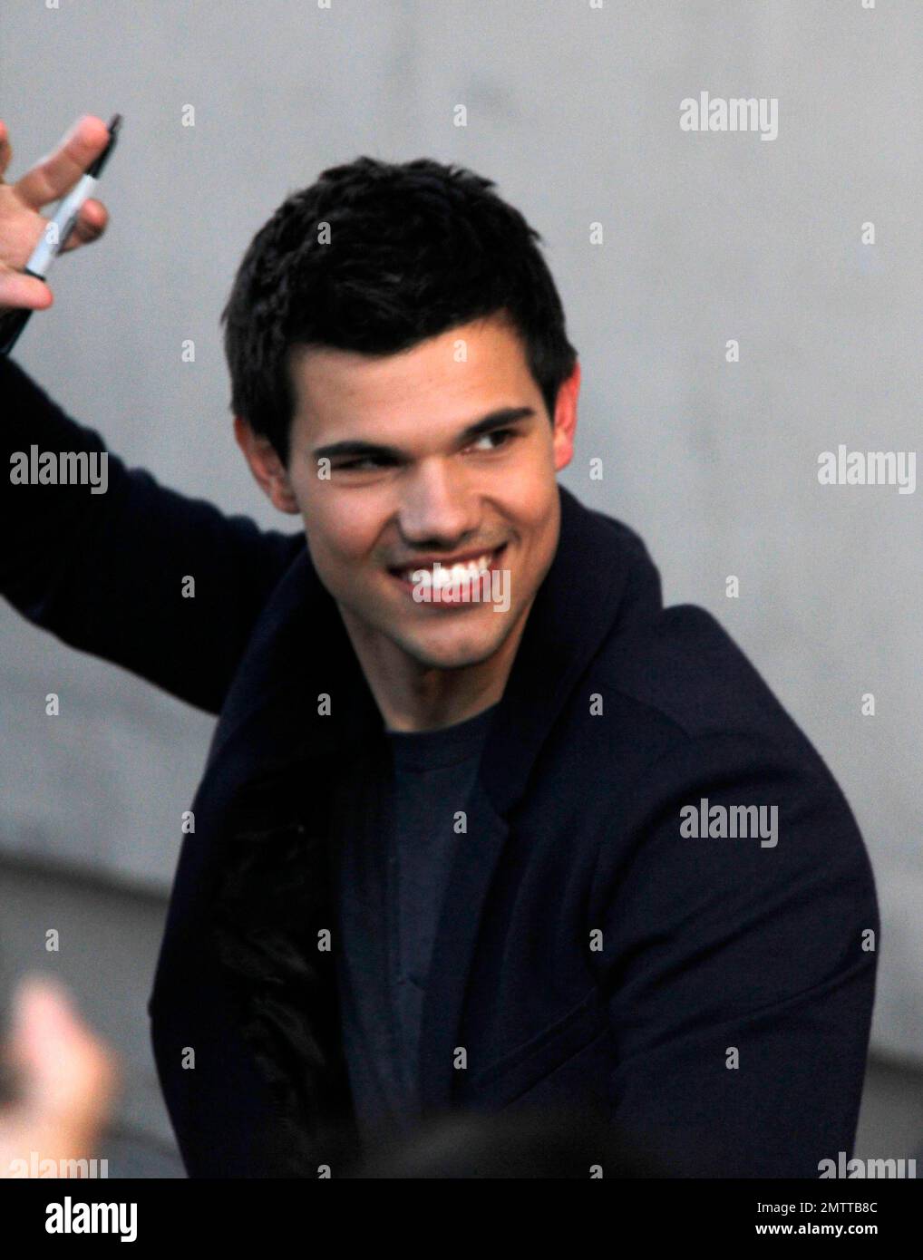 Taylor Lautner waves at fans as he leaves the Jimmy Kimmel Show. Los ...