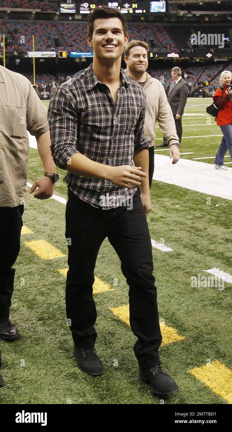 Taylor Lautner signs an autograph while on the football field at ...