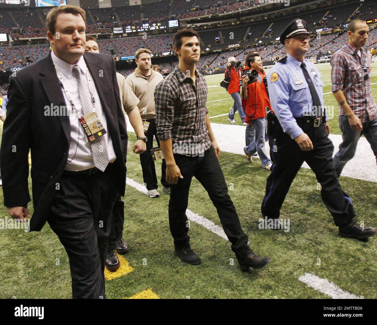 Taylor Lautner signs an autograph while on the football field at ...