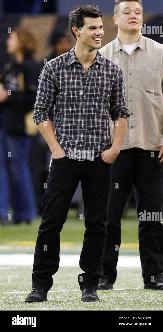 Taylor Lautner signs an autograph while on the football field at ...
