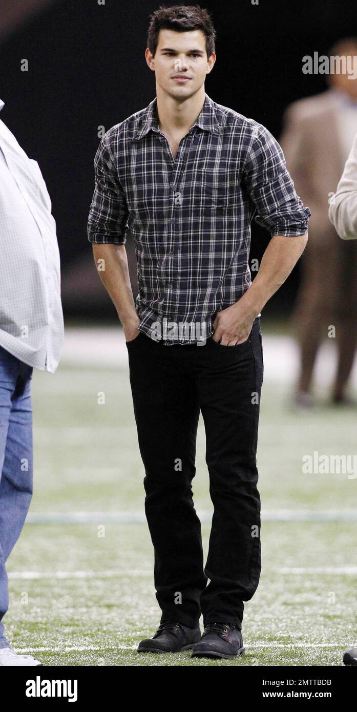 Taylor Lautner signs an autograph while on the football field at ...