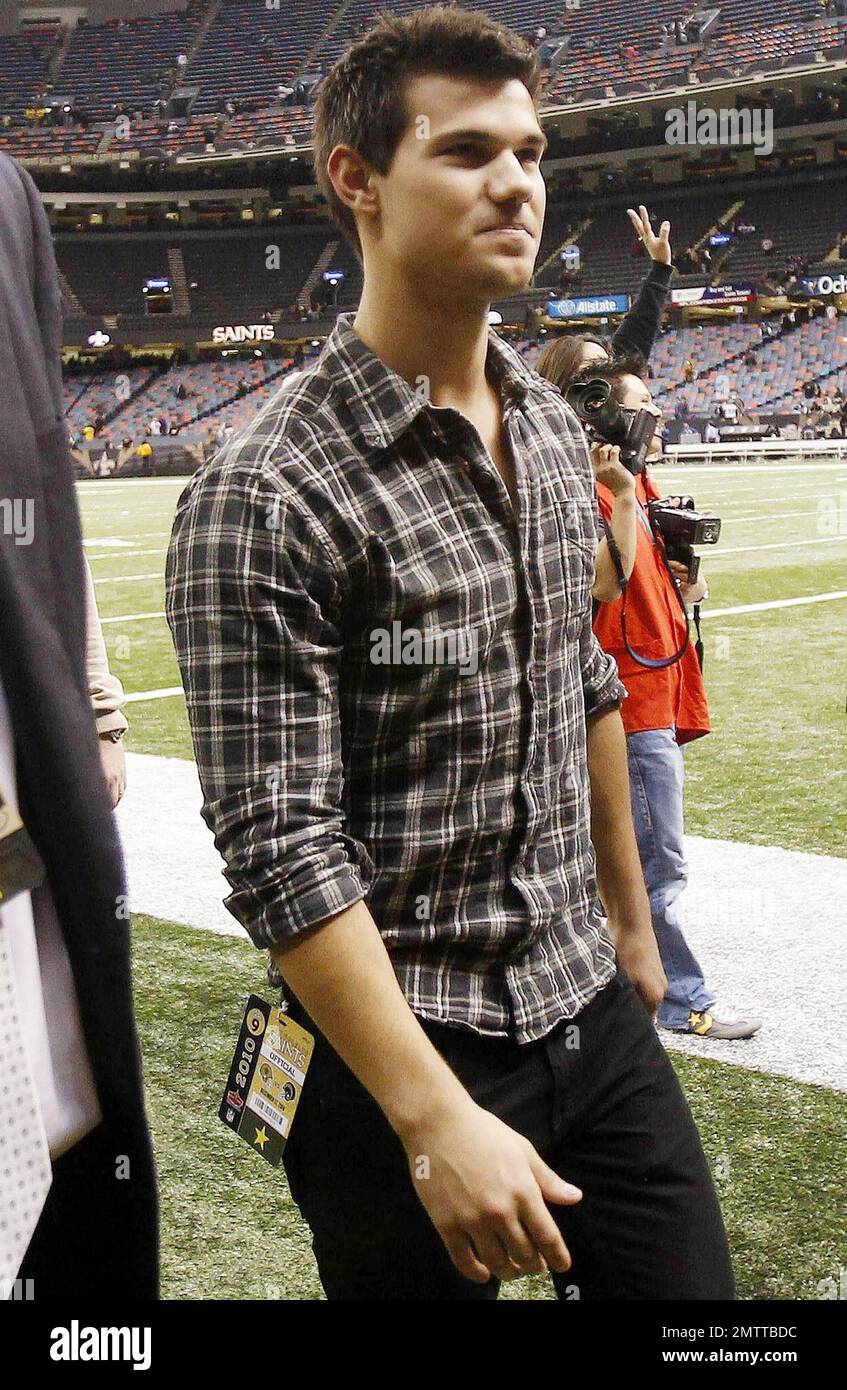 Taylor Lautner signs an autograph while on the football field at ...
