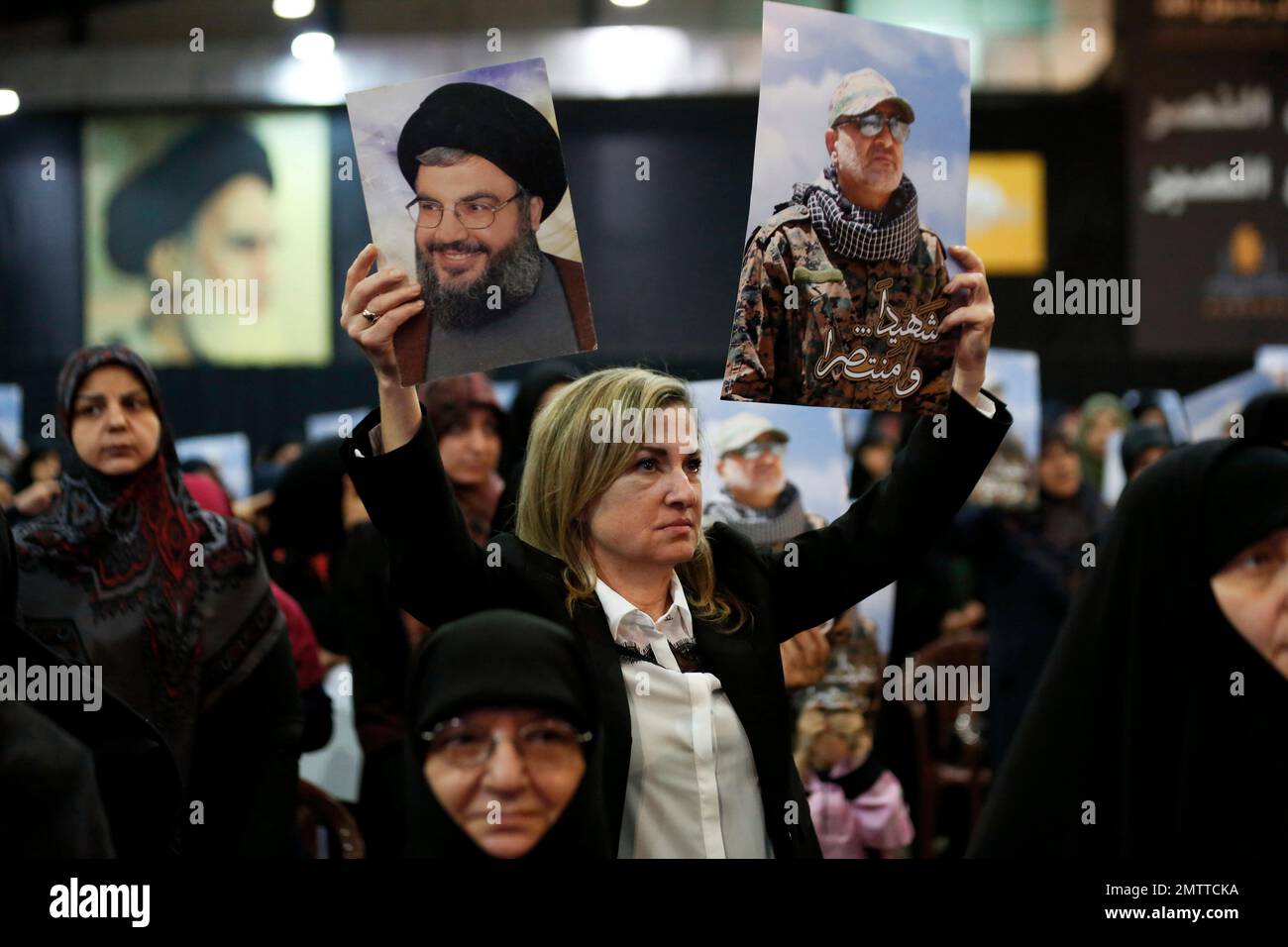 A woman holds up a picture of Hezbollah leader Sheik Hassan Nasrallah ...
