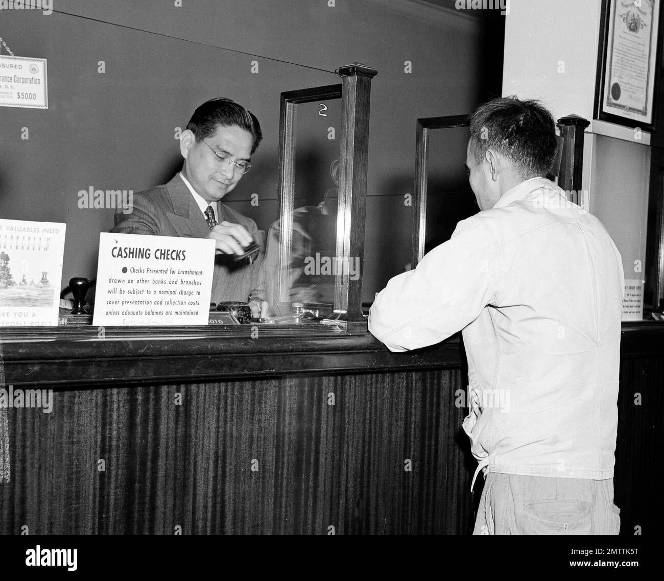 George Haramoto, teller at the branch of the California Bank in Los ...