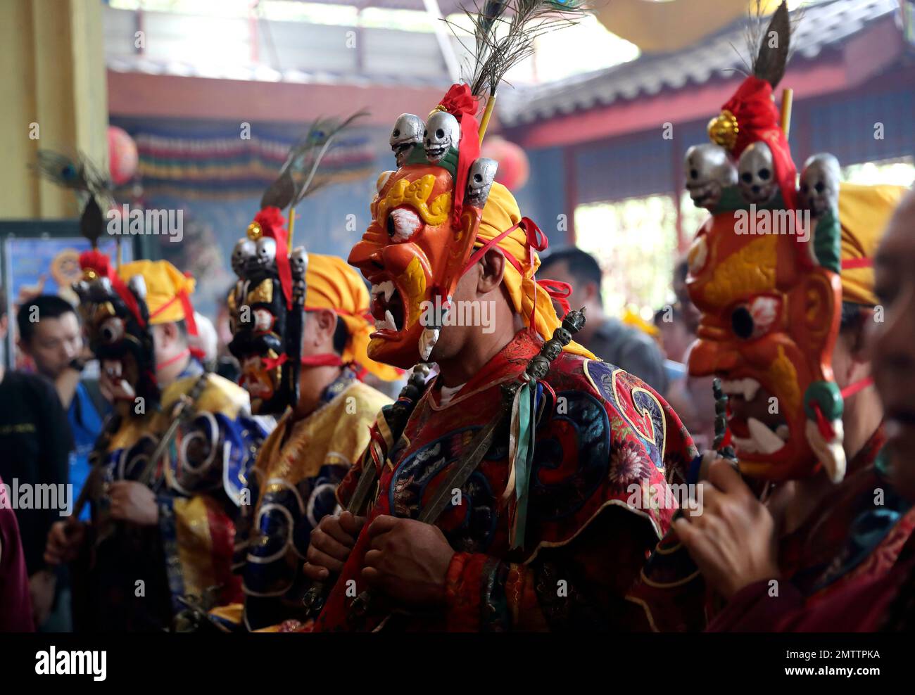 Monks wearing magnificent costumes and masks perform prayers before the ...