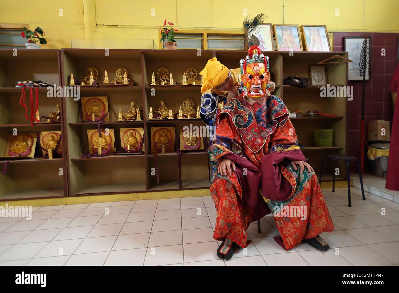 A monk prepares magnificent costumes and masks to perform prayers ...